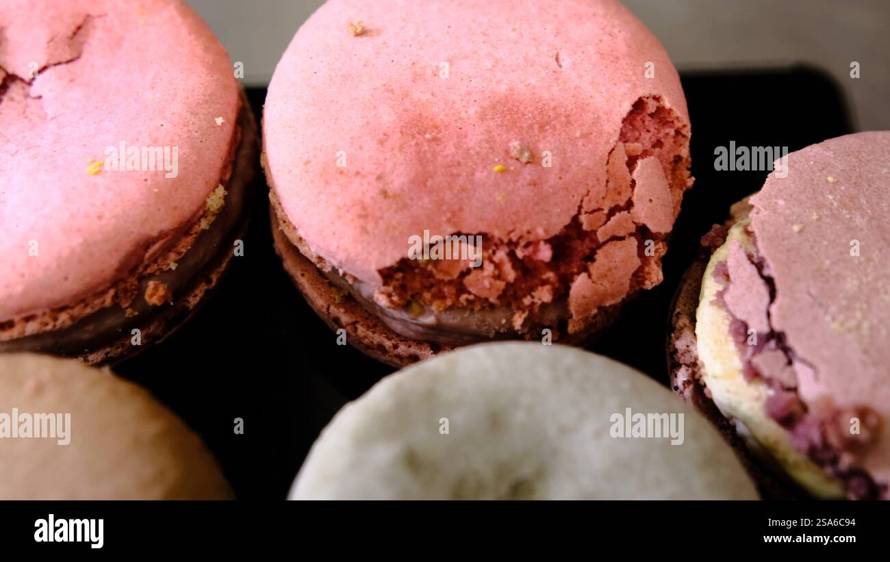 Damaged colorful macarons in close-up showing imperfections and cracks ...