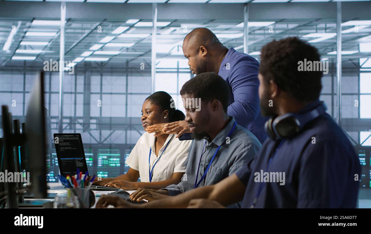 Data center team leader supervising engineers implementing AI predictive maintenance systems ...