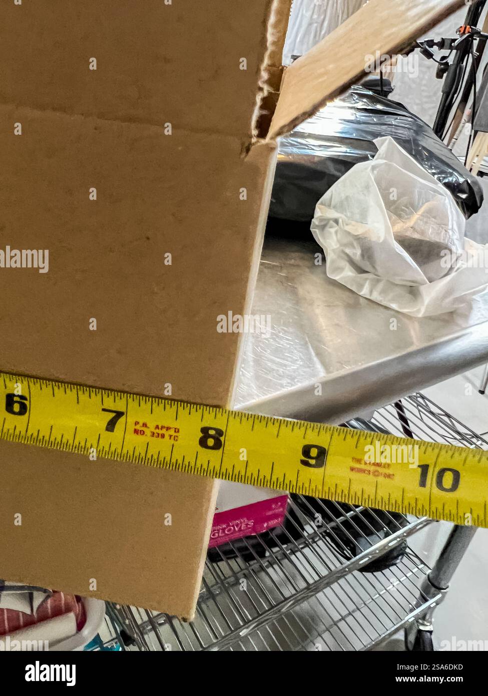 Measuring cardboard box dimensions with tape measure Stock Photo - Alamy