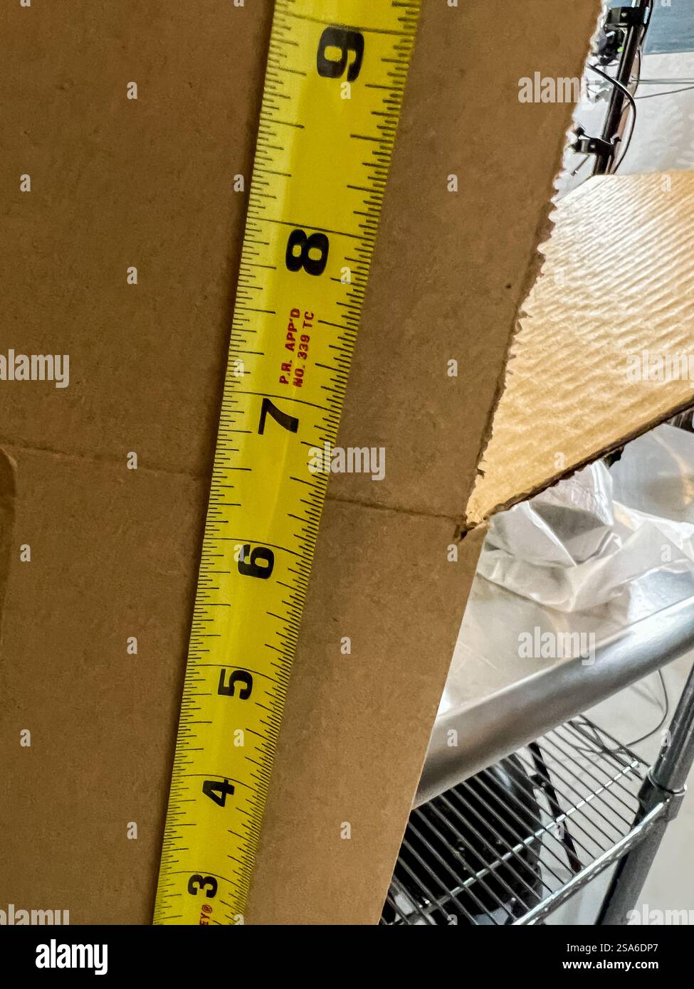 Measuring cardboard box dimensions with tape measure Stock Photo - Alamy