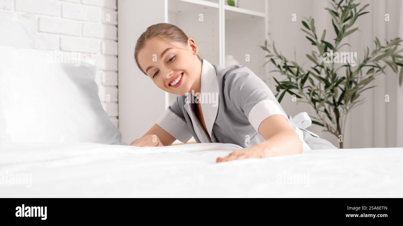 Young chambermaid making bed in room Stock Photo - Alamy