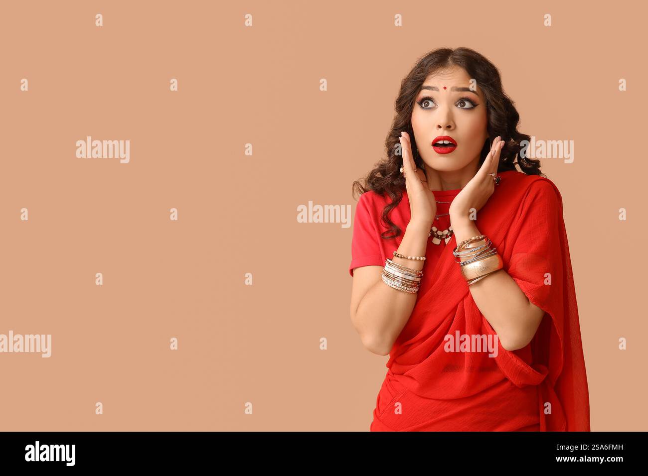 Beautiful shocked Indian woman in sari on brown background Stock Photo ...