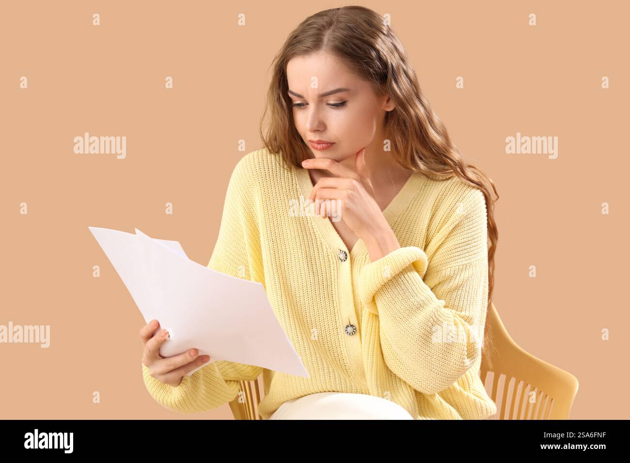 Beautiful actress with film script in chair on beige background Stock ...