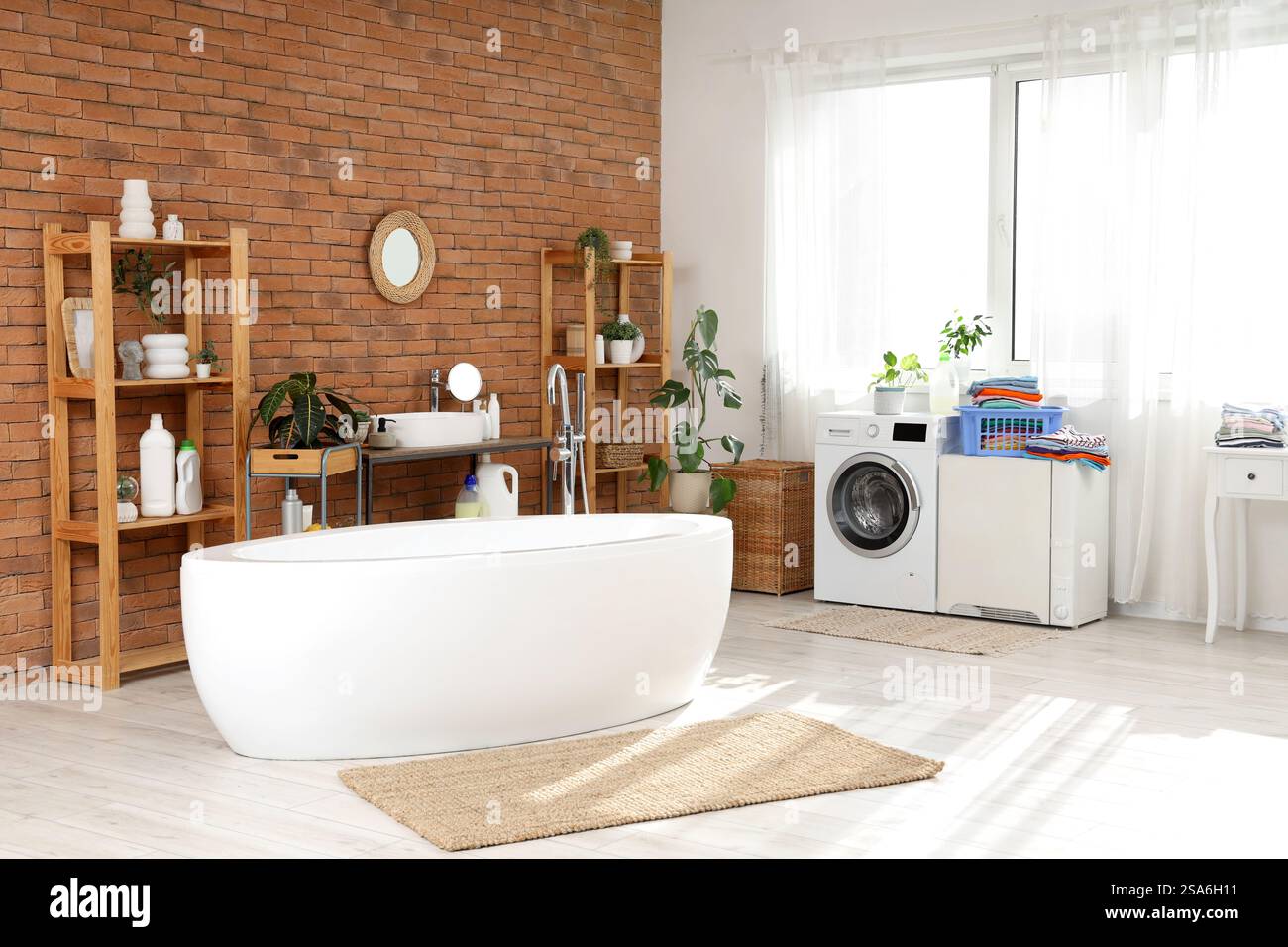 Interior of modern bathroom with bathtub, washing machine and shelving ...