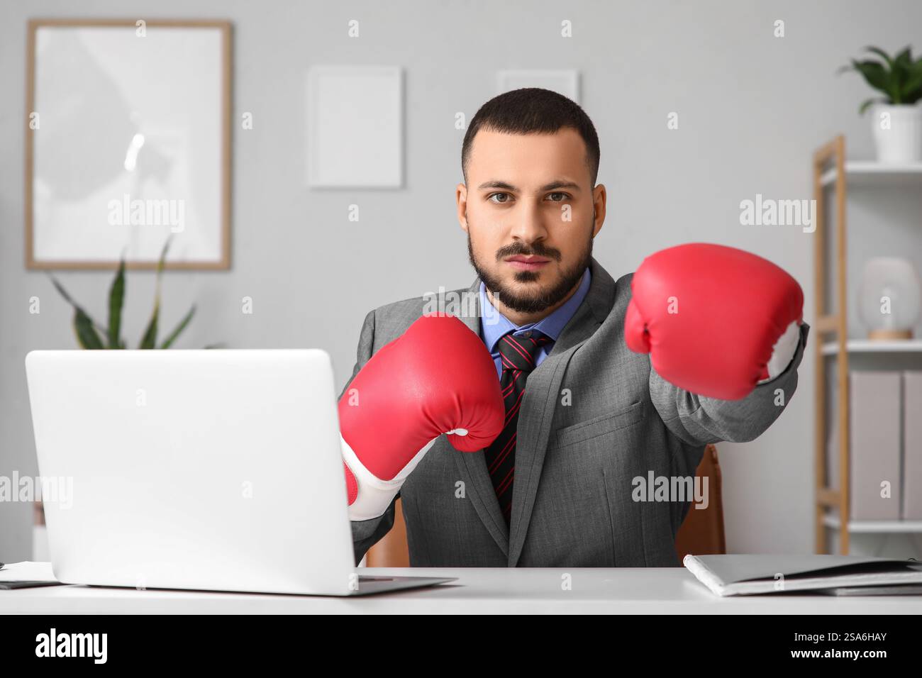 Young businessman with boxing gloves at table in office. Knockout ...