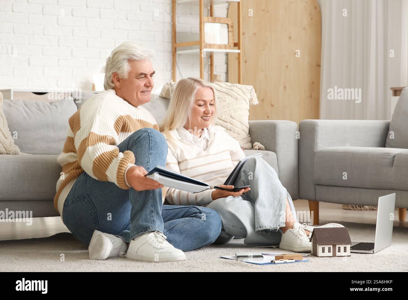 Senior couple calculating utility bills on floor at home Stock Photo ...