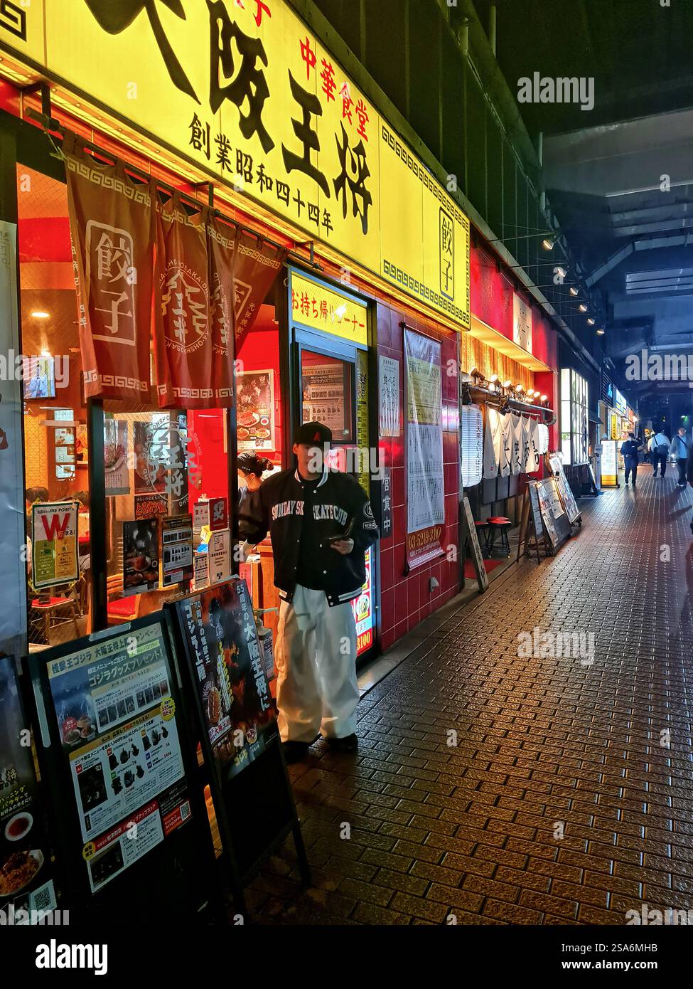 Row of restaurants at night in Akabane in Tokyo, Japan under a train ...