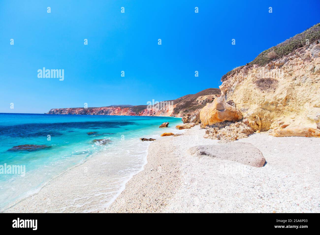 Idyllic beach surrounded by beautiful cliffs dotted with sea caves on ...