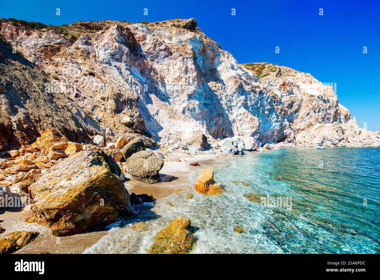 Idyllic beach surrounded by beautiful cliffs dotted with sea caves on ...