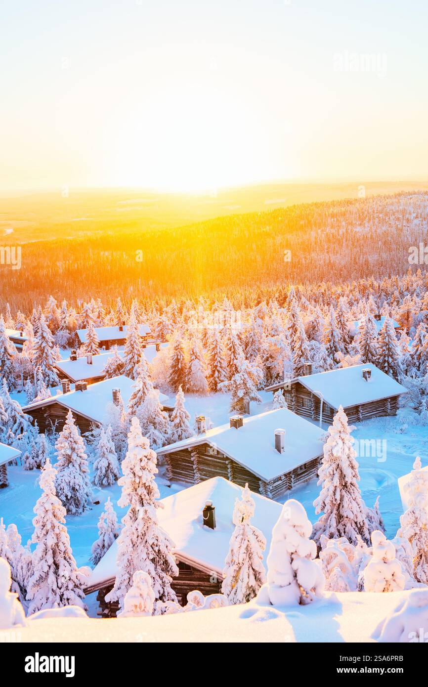 Stunning sunset view over wooden huts and snow covered trees in Finnish ...