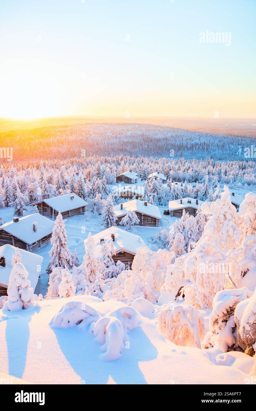 Stunning sunset view over wooden huts and snow covered trees in Finnish ...