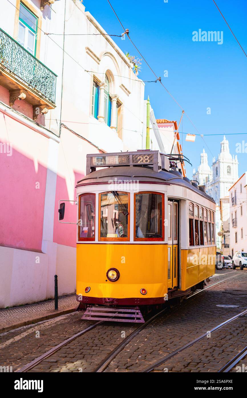 Old yellow tram on quiet street in Alfama district in central Lisbon in ...