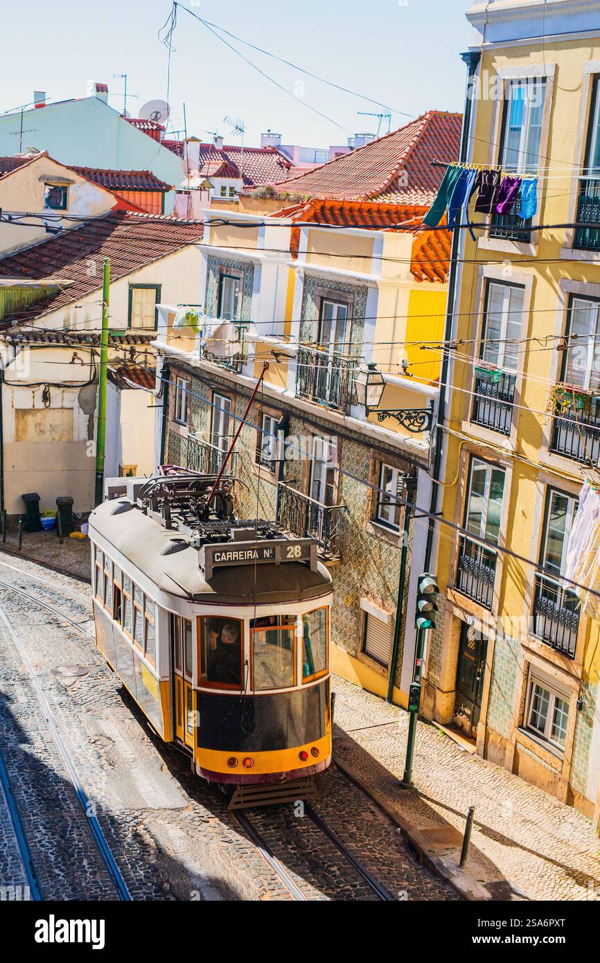 Old yellow tram on quiet street in Alfama district in central Lisbon in ...