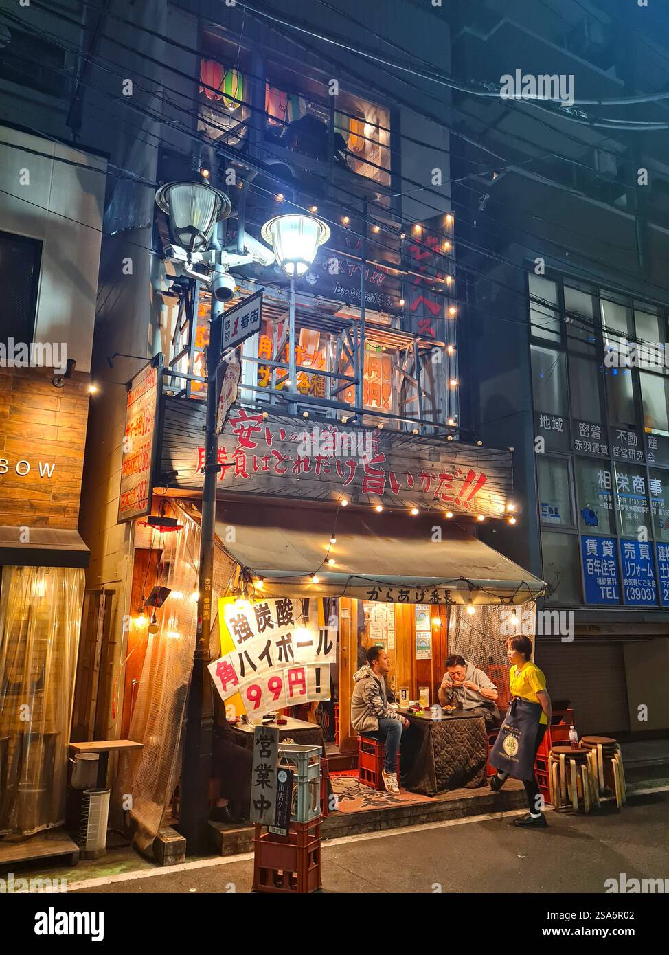 Tokyo night scene with a restaurant bar at night with people sitting ...