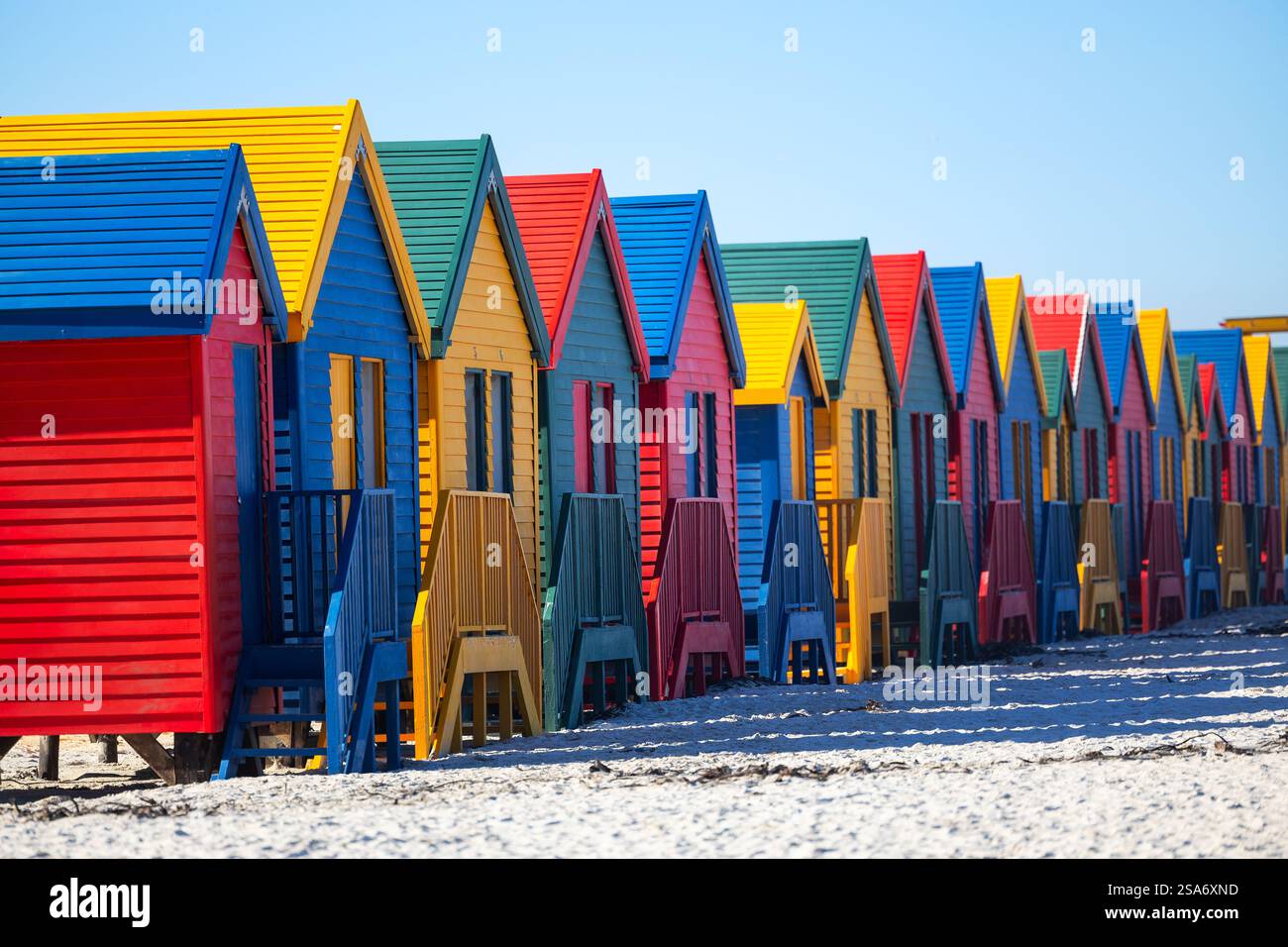 Row of distinctive blue, yellow, red, and green Victorian-style beach ...
