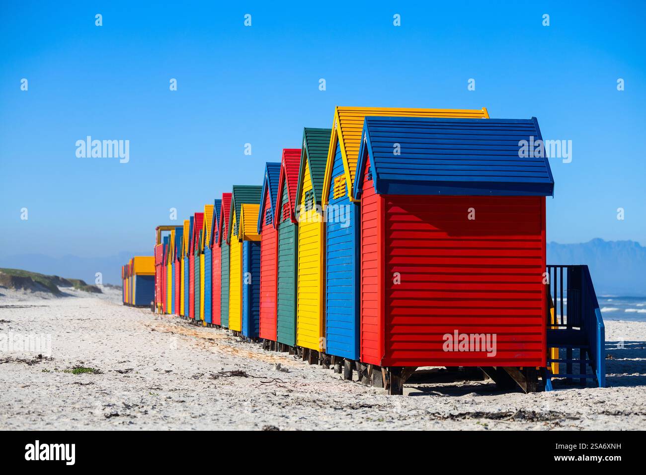Row of distinctive blue, yellow, red, and green Victorian-style beach ...