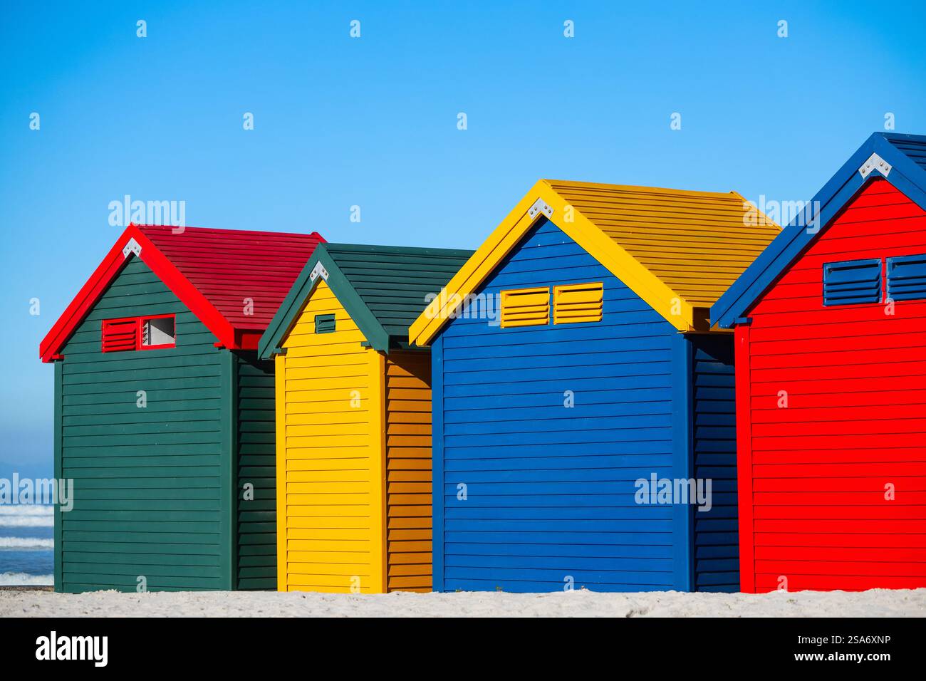 Row of distinctive blue, yellow, red, and green Victorian-style beach ...