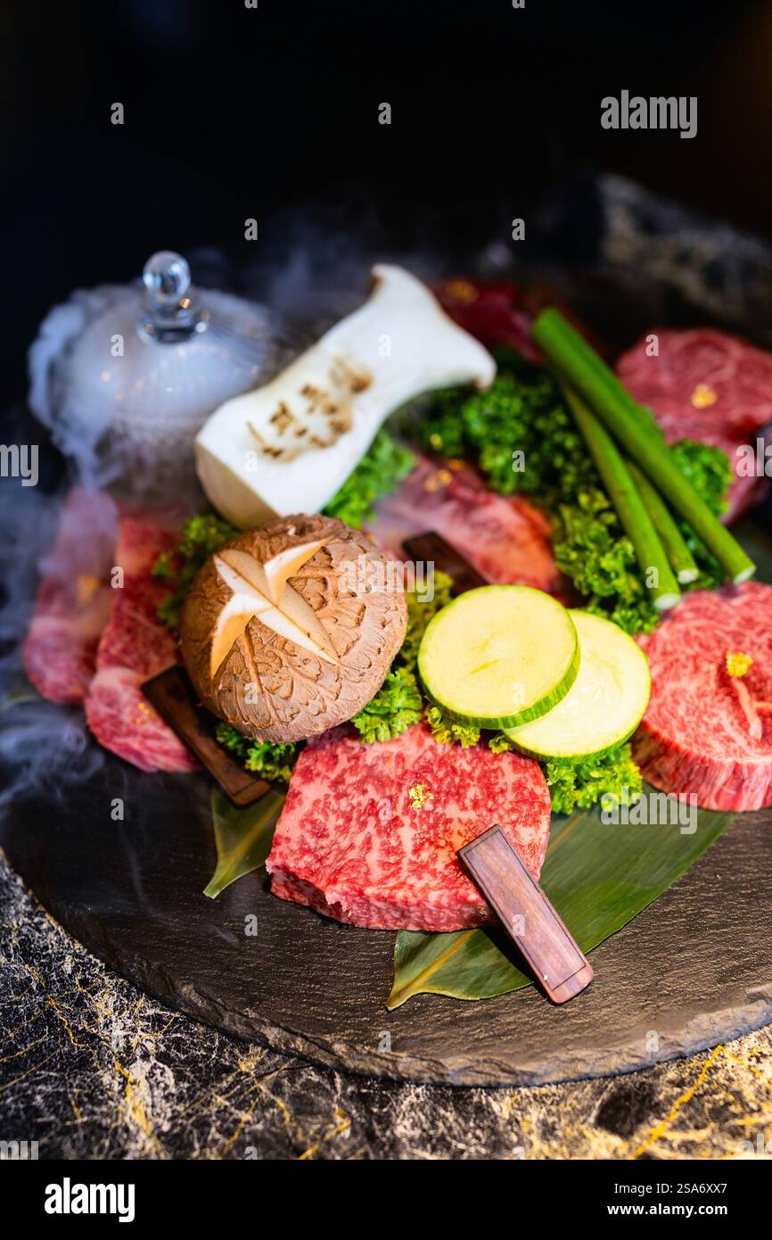 Marbled Hanwoo beef arranged on banana leaf with king mushroom, sliced ...