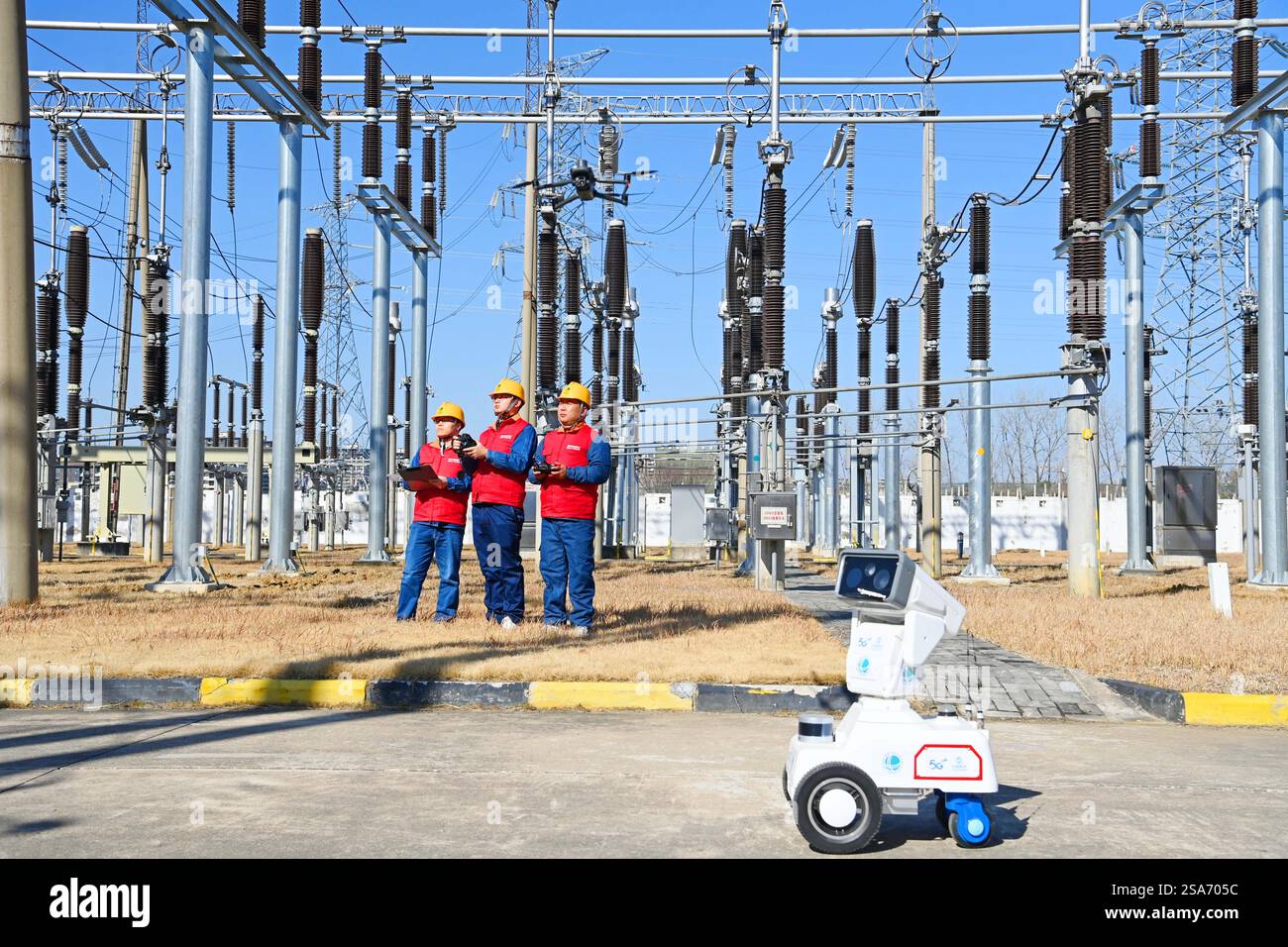 A 5G intelligent inspection robot and staff use a drone to conduct a ...