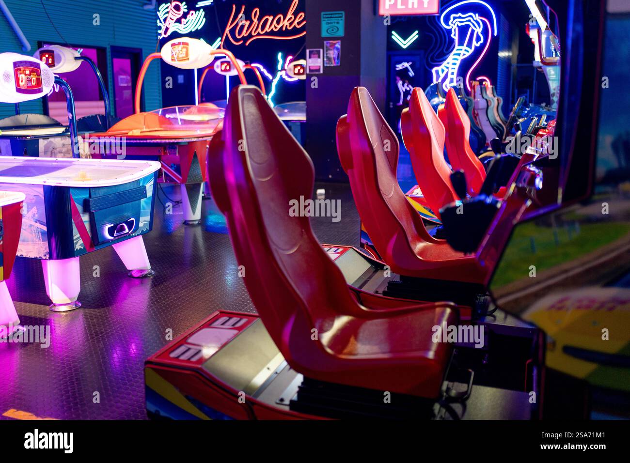 Game Center: Empty red gaming chairs in illuminated arcade game zone ...