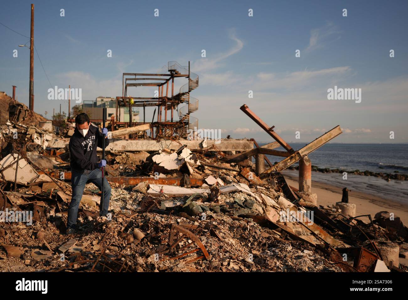 Tony Lai rakes through the remains of his fire-ravaged beachfront ...