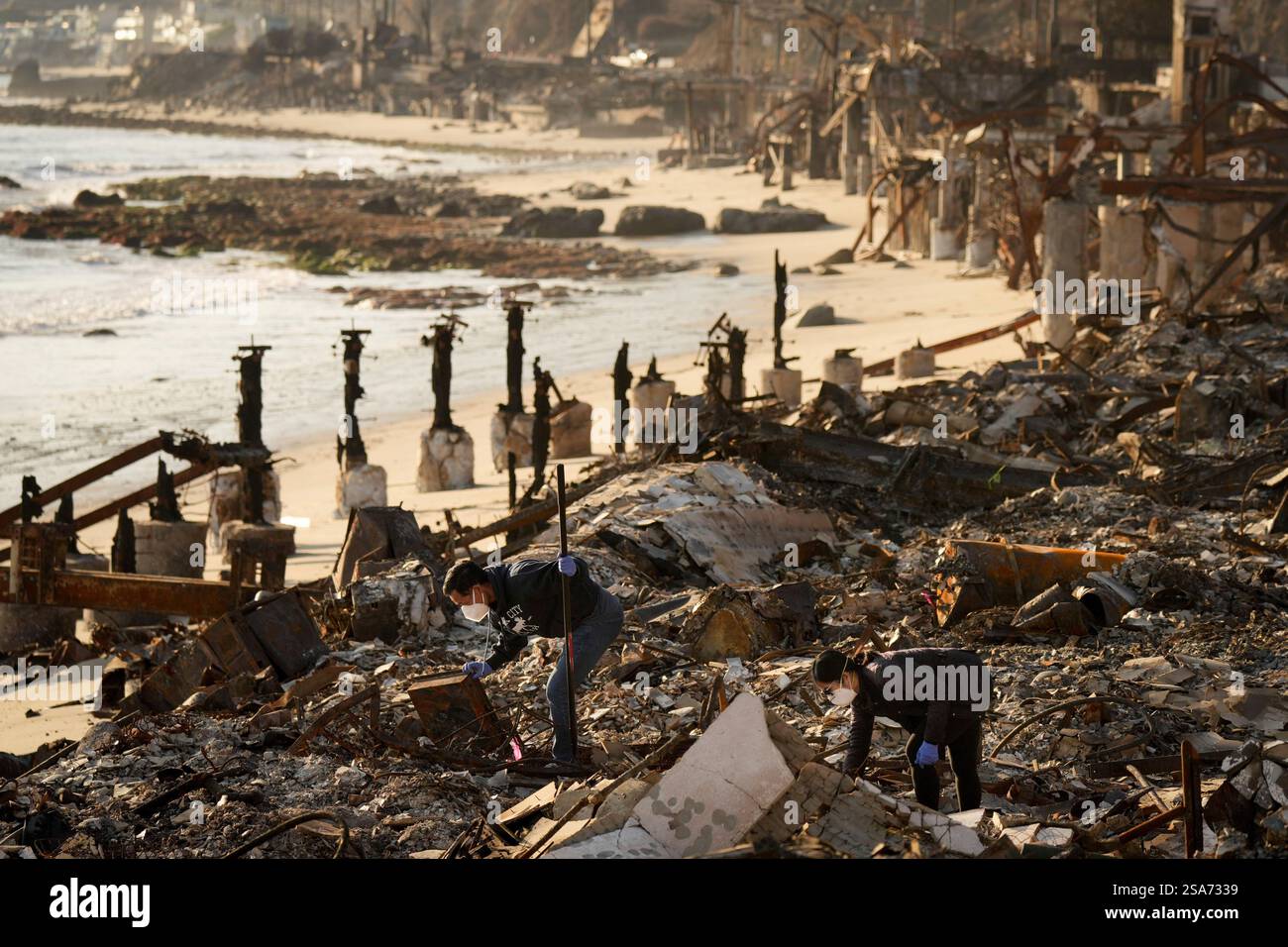 Tony Lai, left, looks through the remains of his fire-ravaged ...