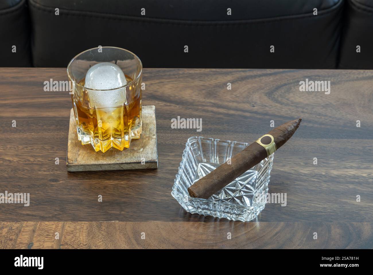 Crystal glass of whisky with an ice cube shaped like a skull inside and ...