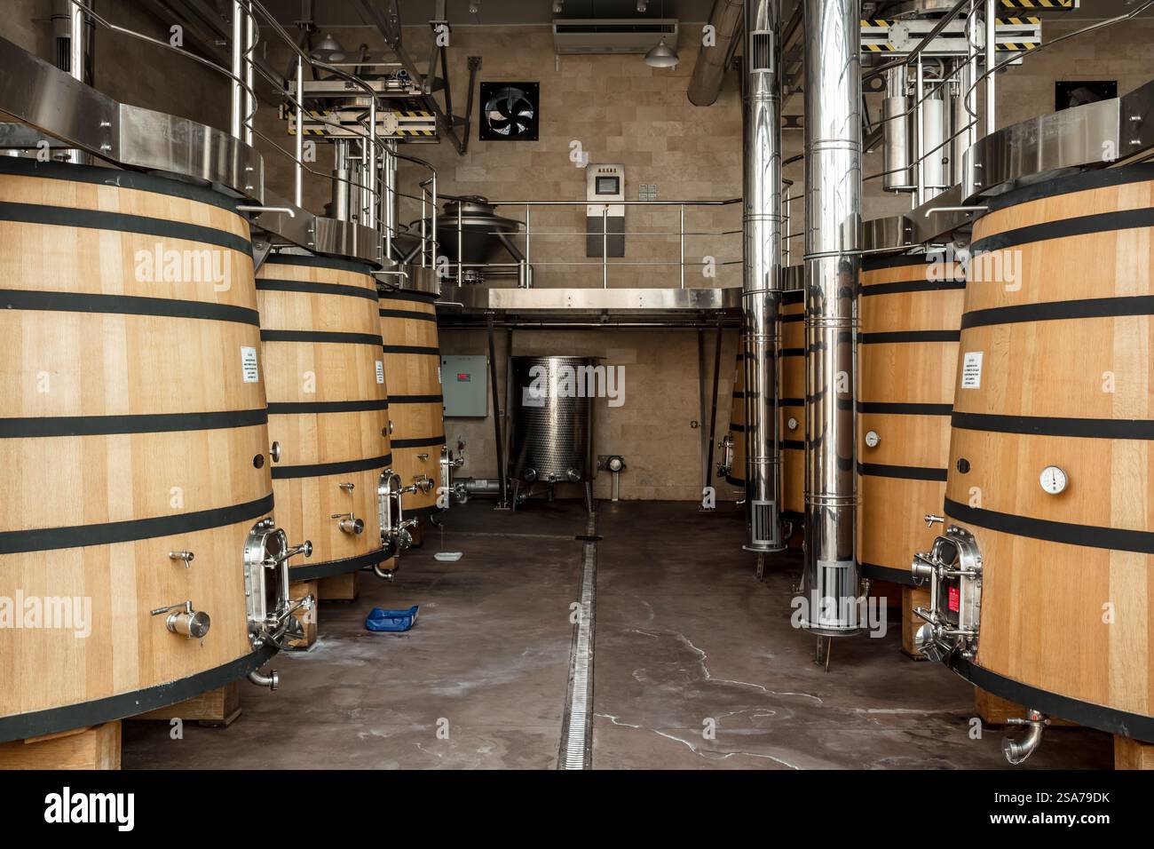 A large industrial building with several large wooden barrels and a ...