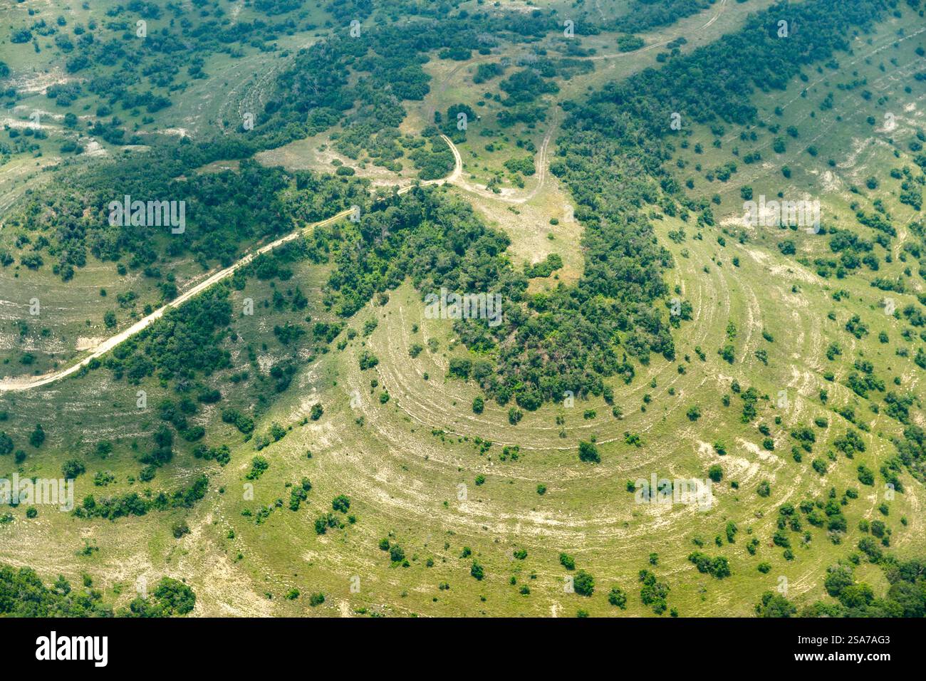 Aerial view of eroded green cliff ridge rising above desert scrub ...