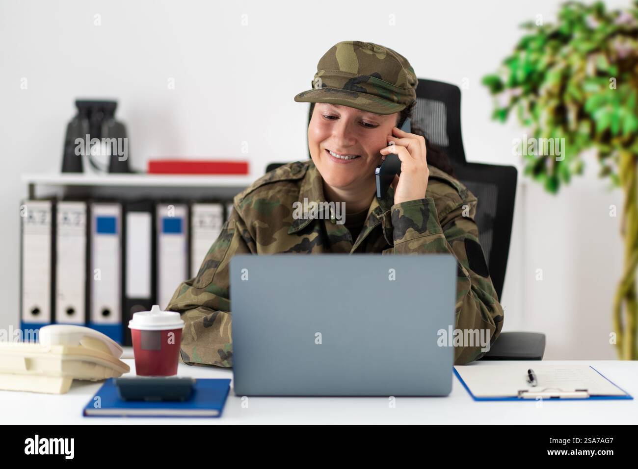 Pretty American soldier behind her computer talking on the phone in the ...