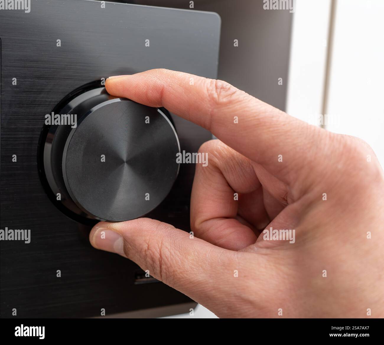 Hand turning the volume knob of an amplifier up to the maximum, Concept ...