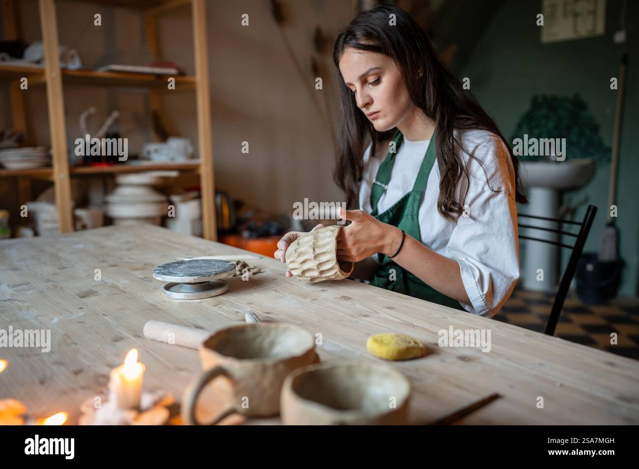 Molding craft ceramics: table in pottery studio with female artist ...