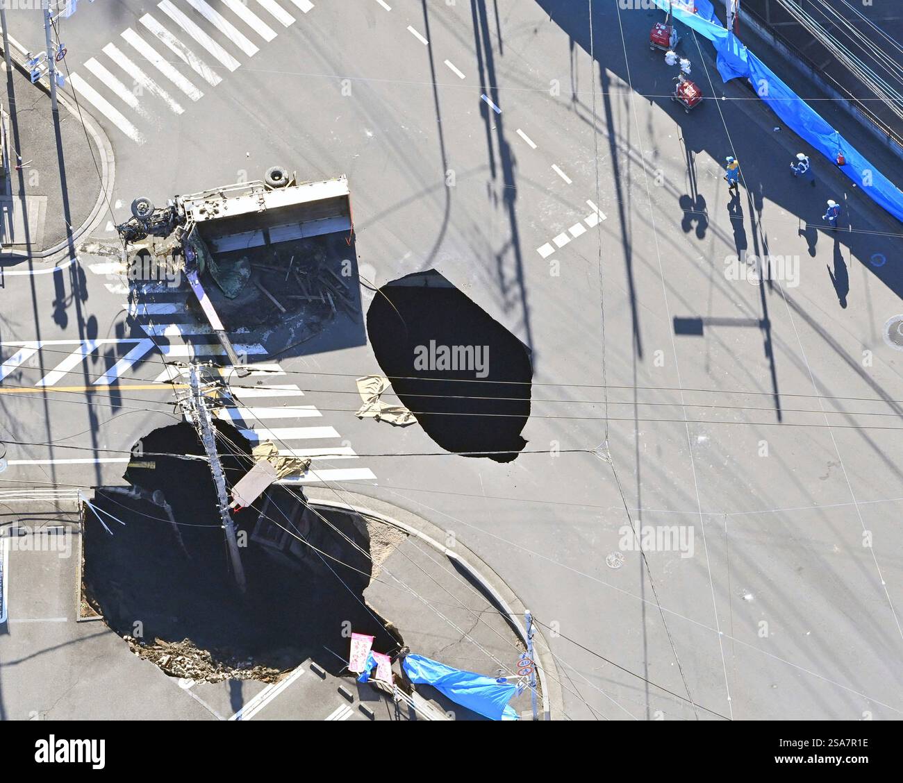 An aerial photo shows sinkholes are seen at an intersection in Yashio ...