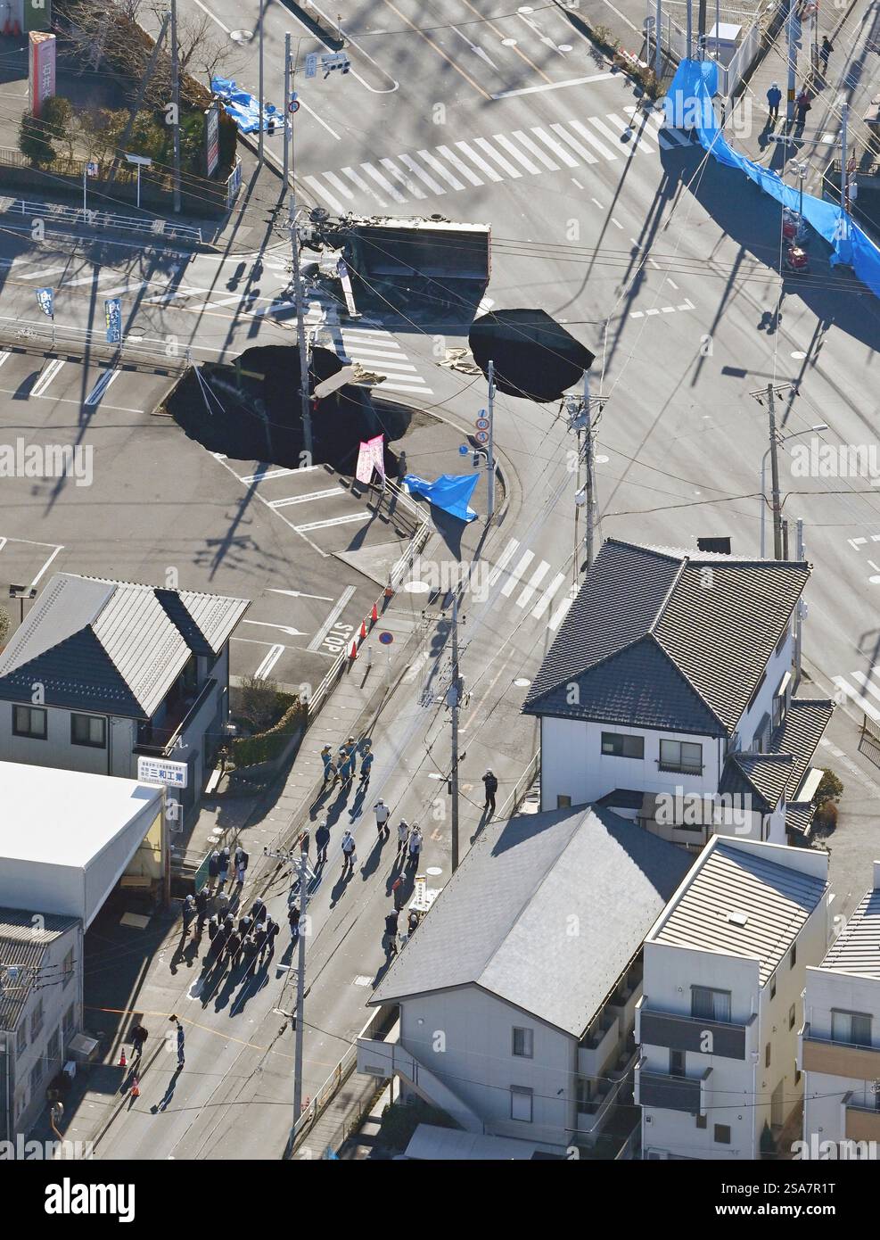 An aerial photo shows sinkholes are seen at an intersection in Yashio ...