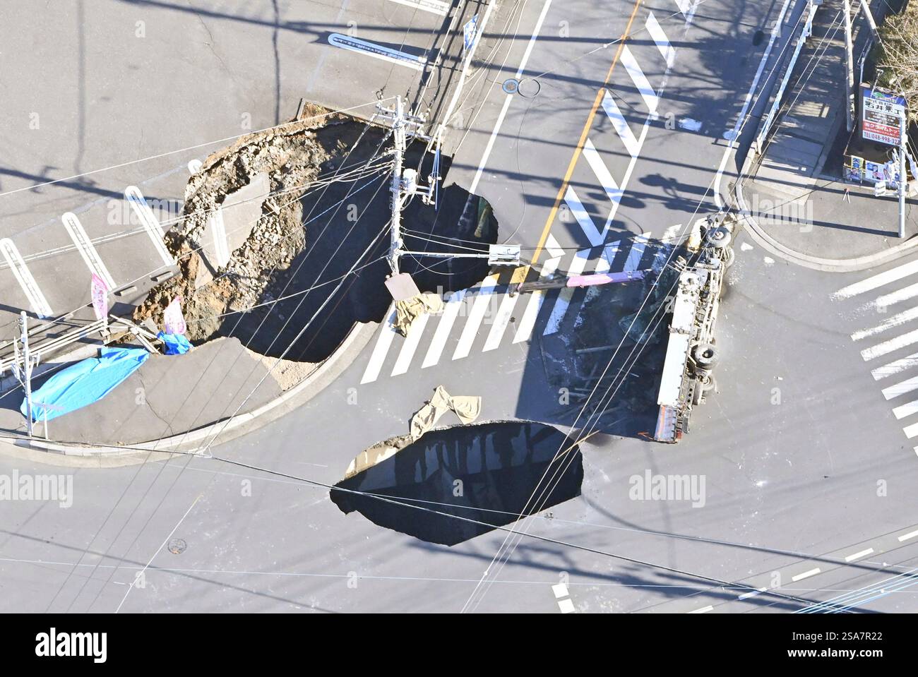 An aerial photo shows sinkholes are seen at an intersection in Yashio ...