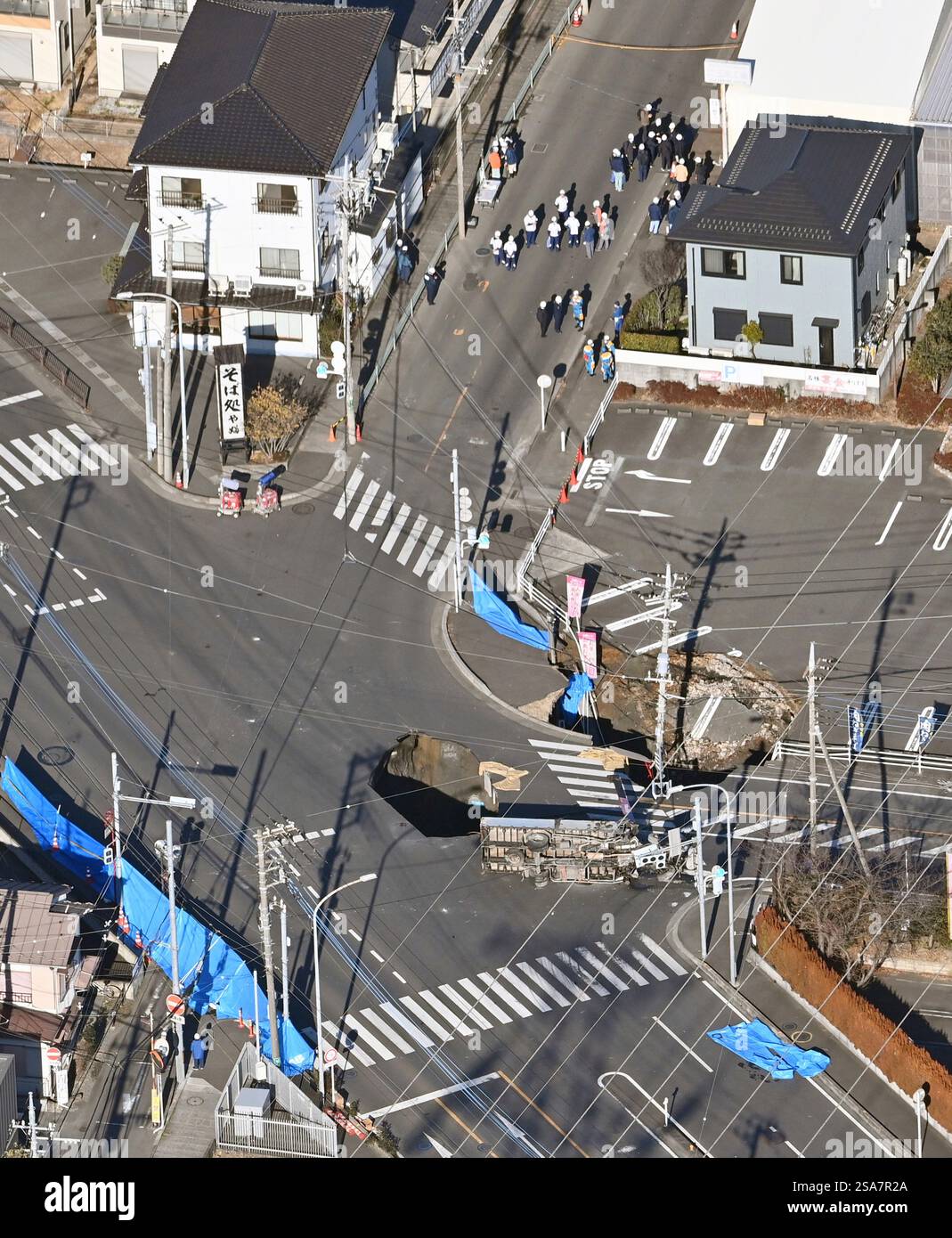 An aerial photo shows sinkholes are seen at an intersection in Yashio ...