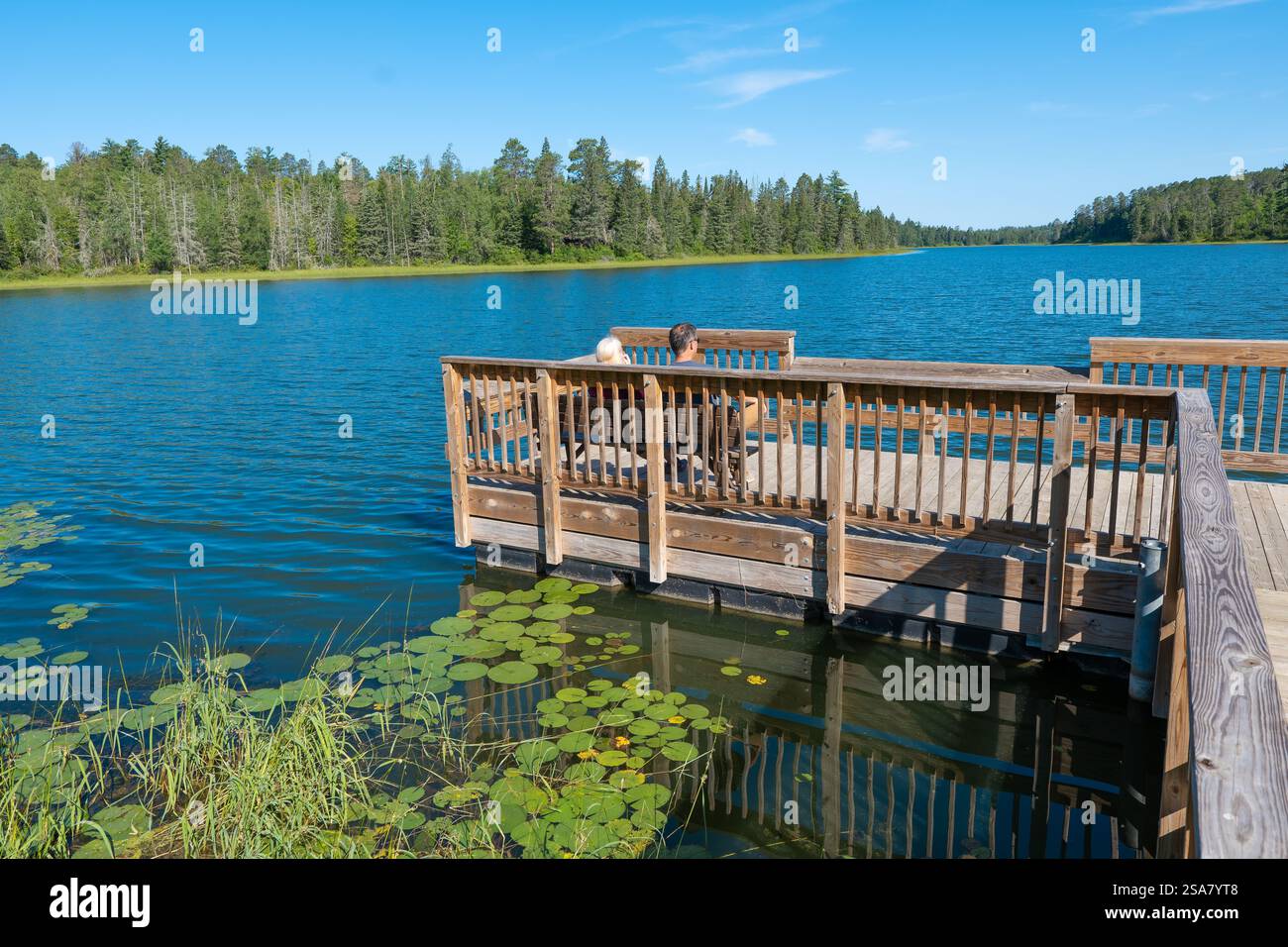 CLEARWATER CO. MN - 11 AUG 2024: A couple relaxing on a wooden bench on ...