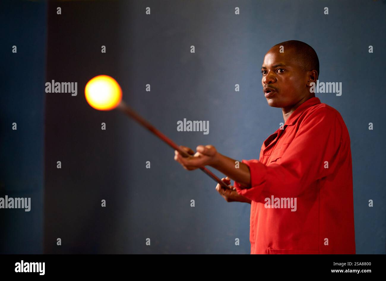 Labor, manufacturing or production and black man glassblower in forge ...