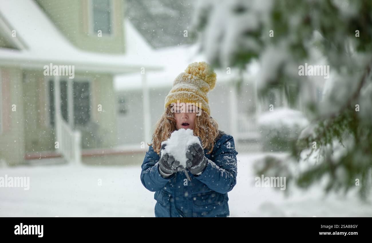 Kid boy play in the snow with a winter hat. Happy kid in warm clothes ...