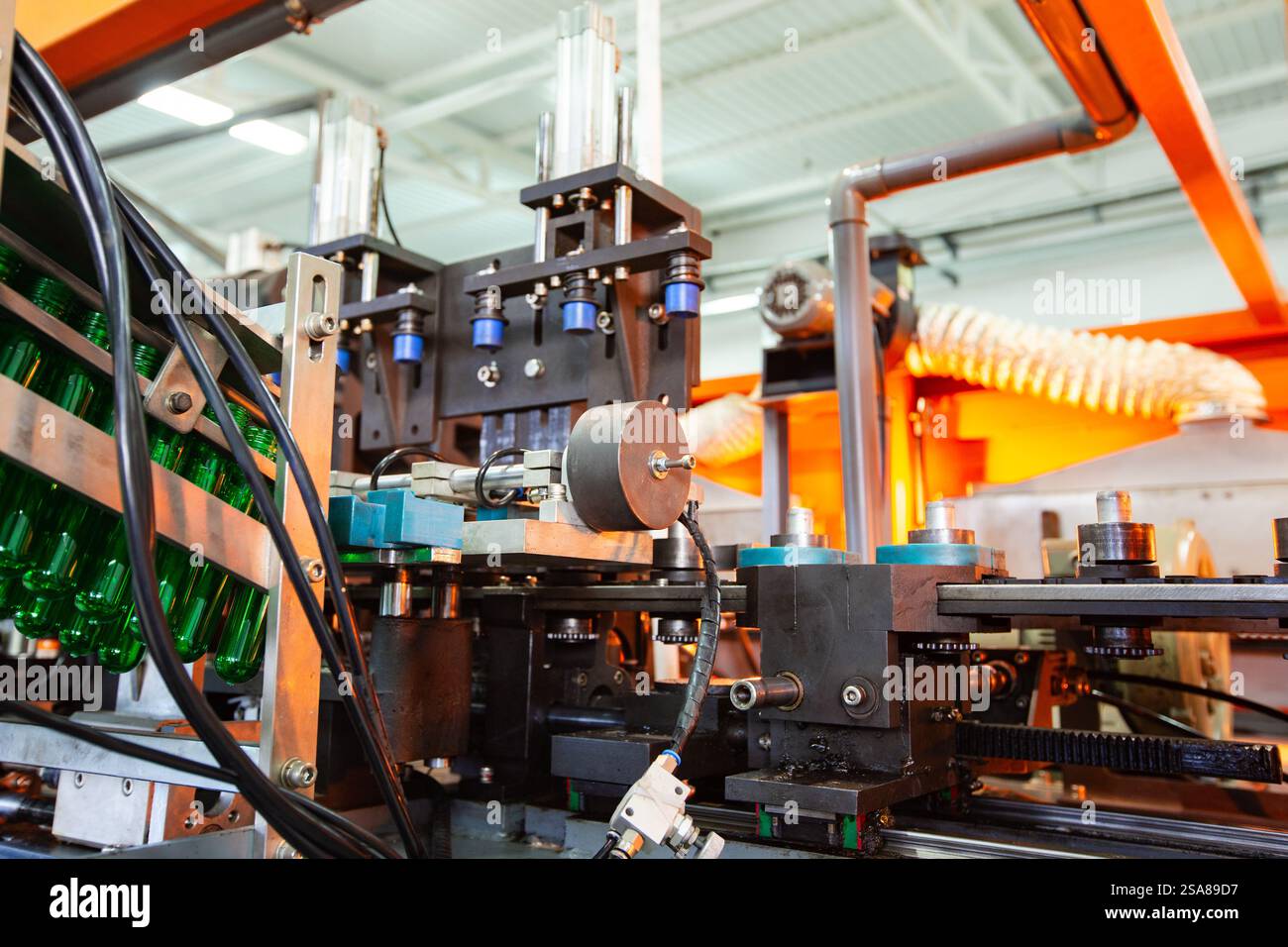 Industrial machinery operates on production line for bottle filling and ...