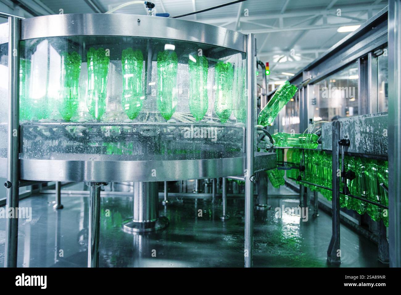 Bottling process in a modern production facility featuring green glass ...