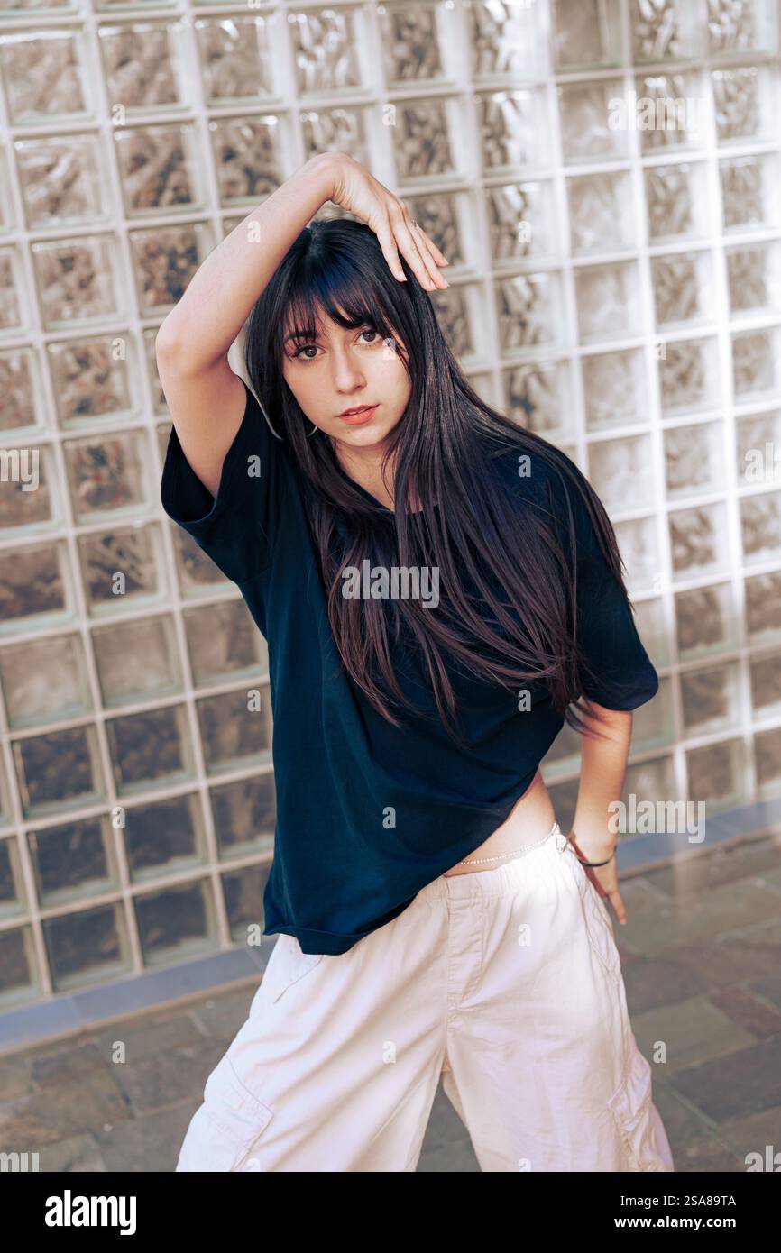 Creative dance expression of a woman in casual attire showcasing fluid movements in an urban ...