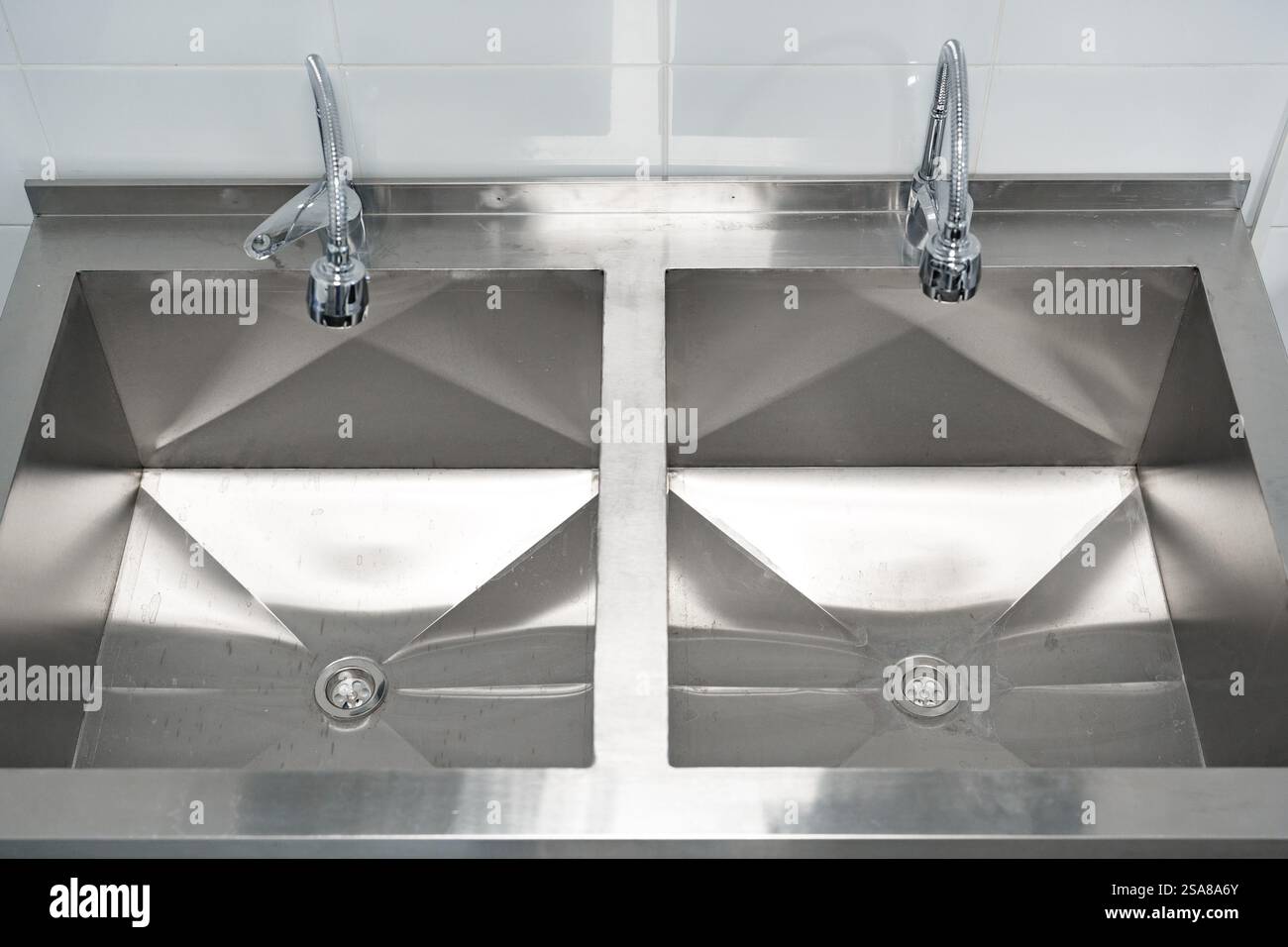 Stainless steel double sink in a kitchen setting with modern fixtures ...
