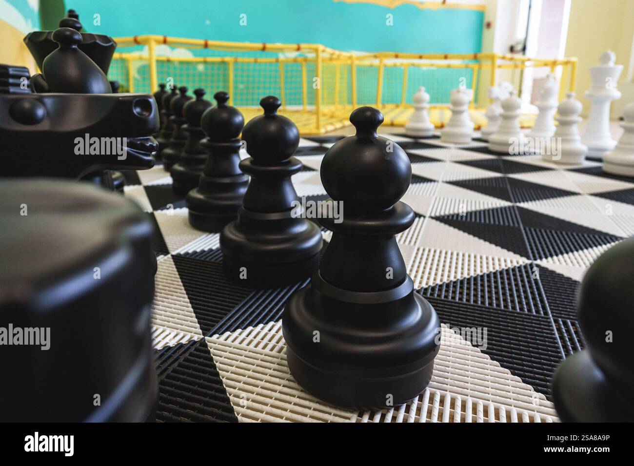 Oversized chess pieces set up on a large checkerboard floor in a ...