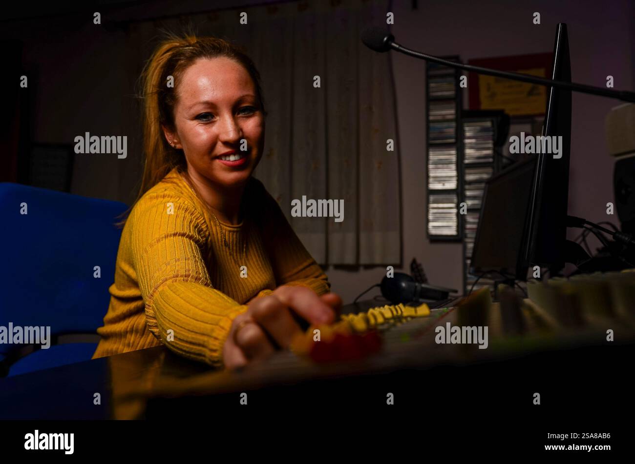 Sound engineer adjusting audio levels on a mixing console in recording ...