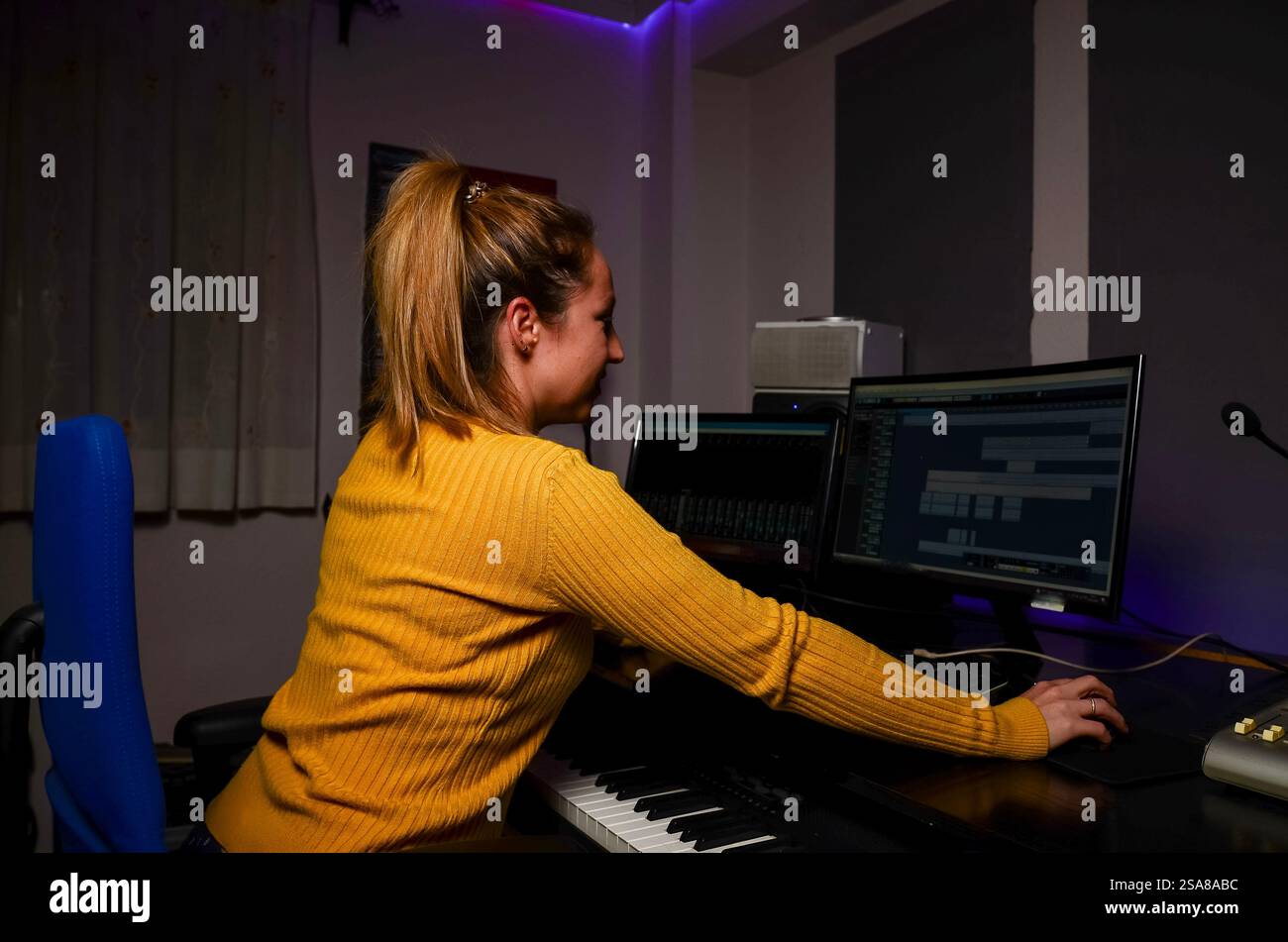 Female music producer composing music using computer software and ...