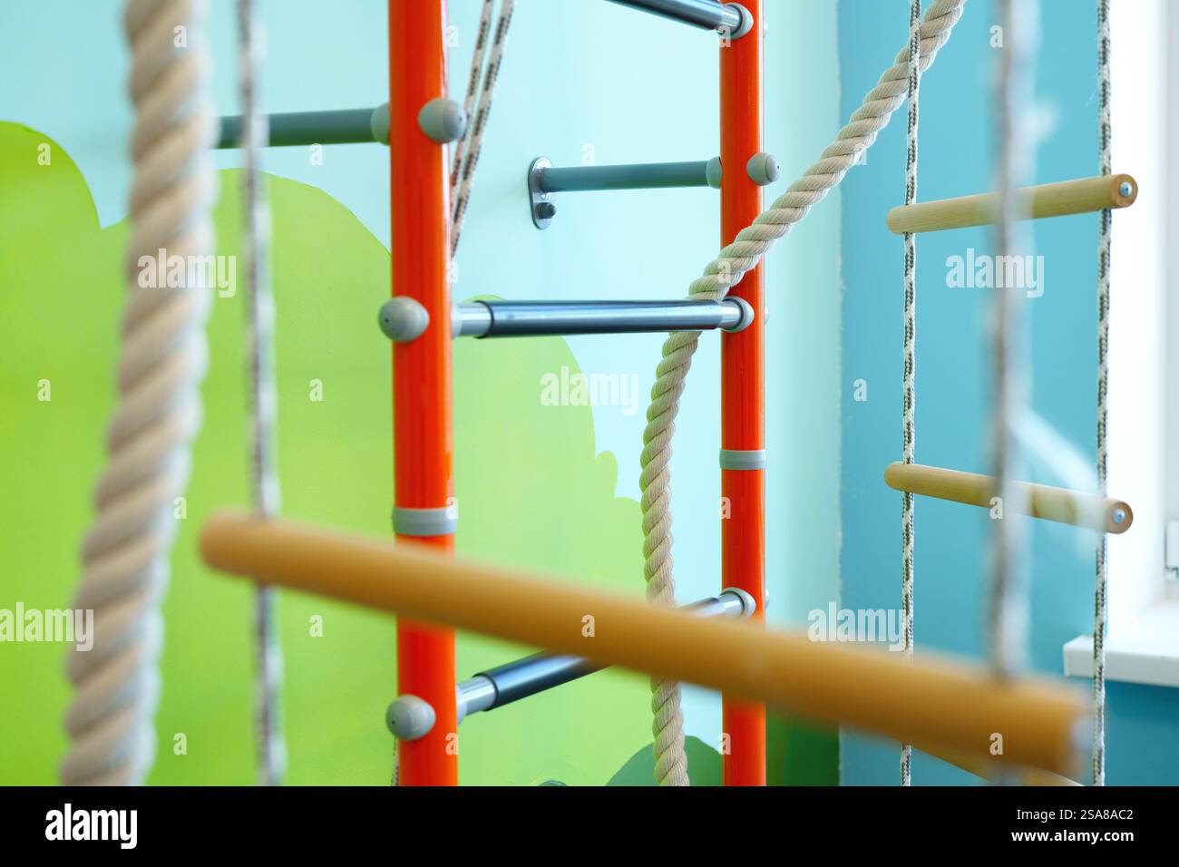Indoor play area features colorful climbing frame with ropes and wooden ...