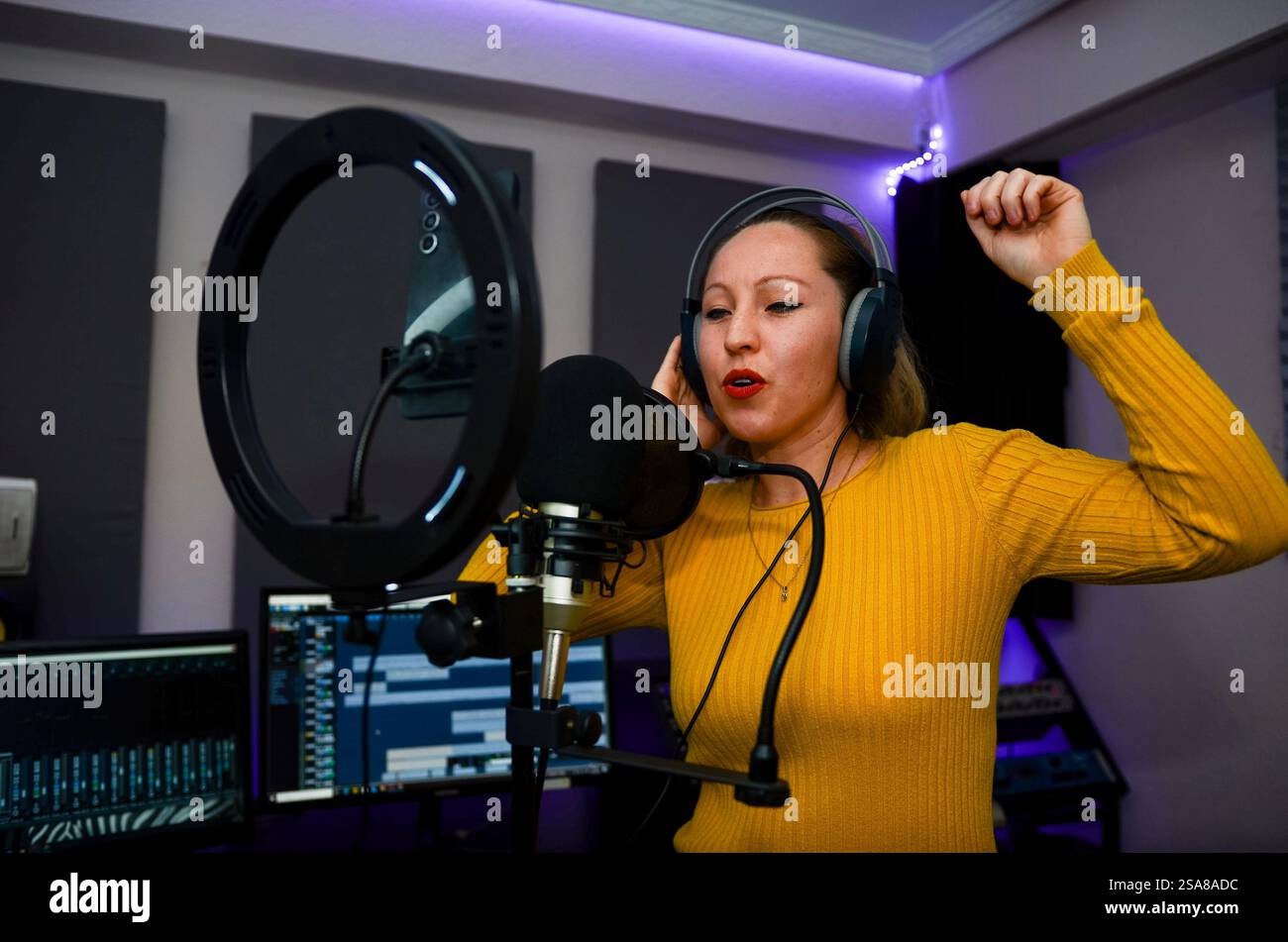 Female singer performing and recording song inside a professional music ...