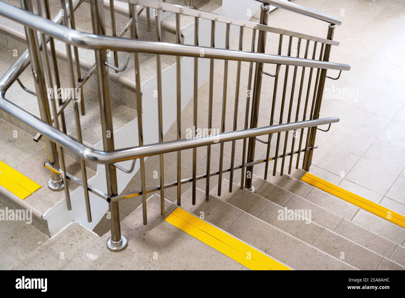 Safety railing guides the path down the staircase in a modern building ...