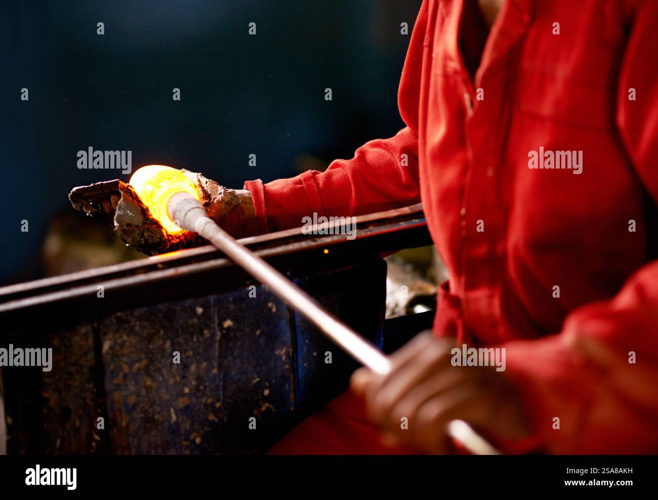 Hands, glassblower and man with blow pipe, technique and equipment with ...